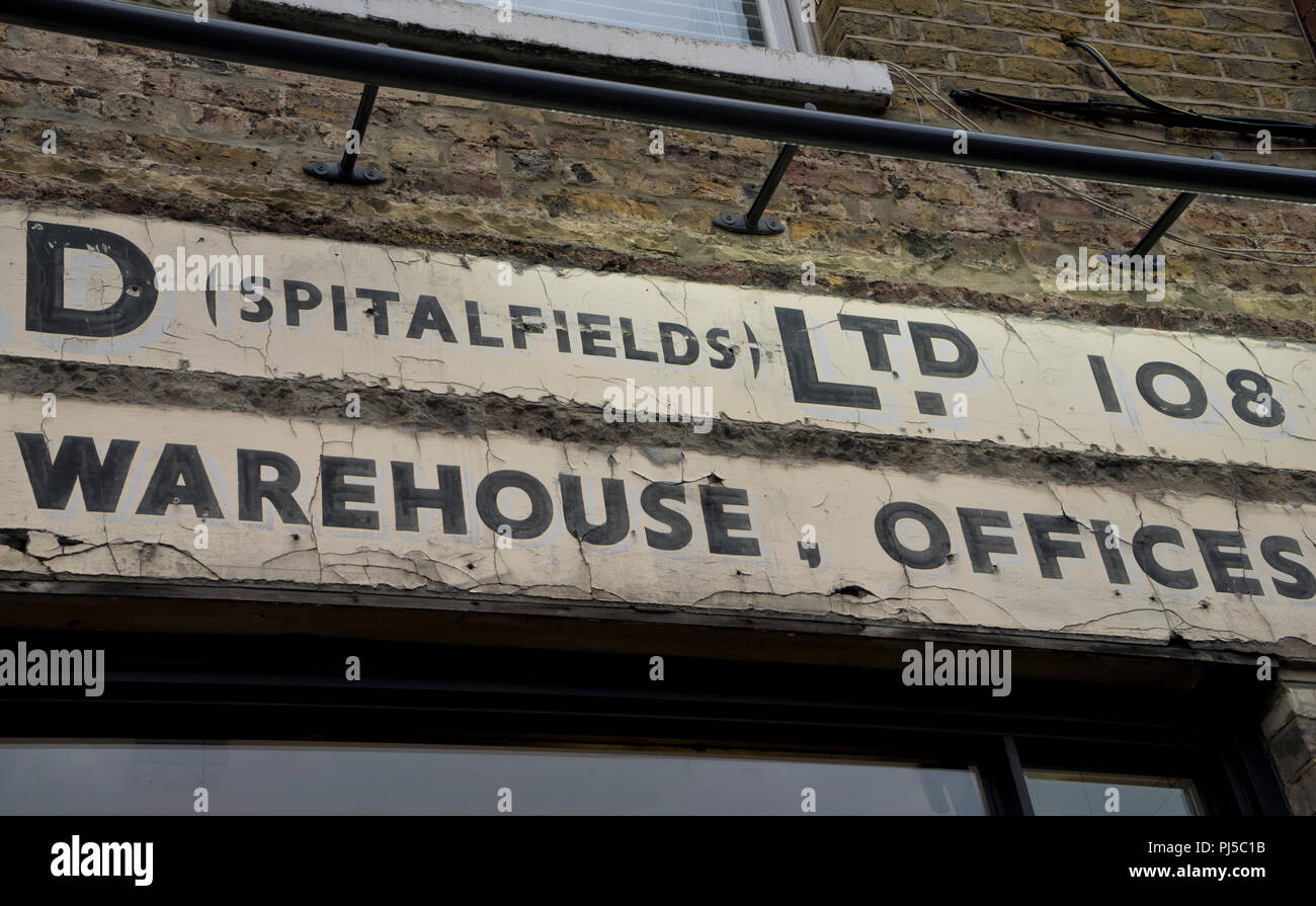 Old 1930s commercial signs on a wall by Spitalfields Church in the City ...