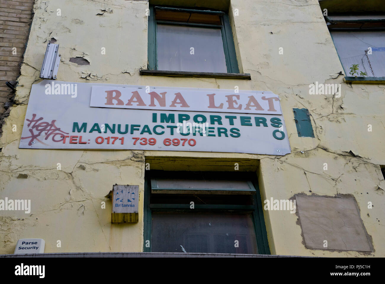 Old 1930s commercial signs on a wall by Spitalfields Church in the City ...