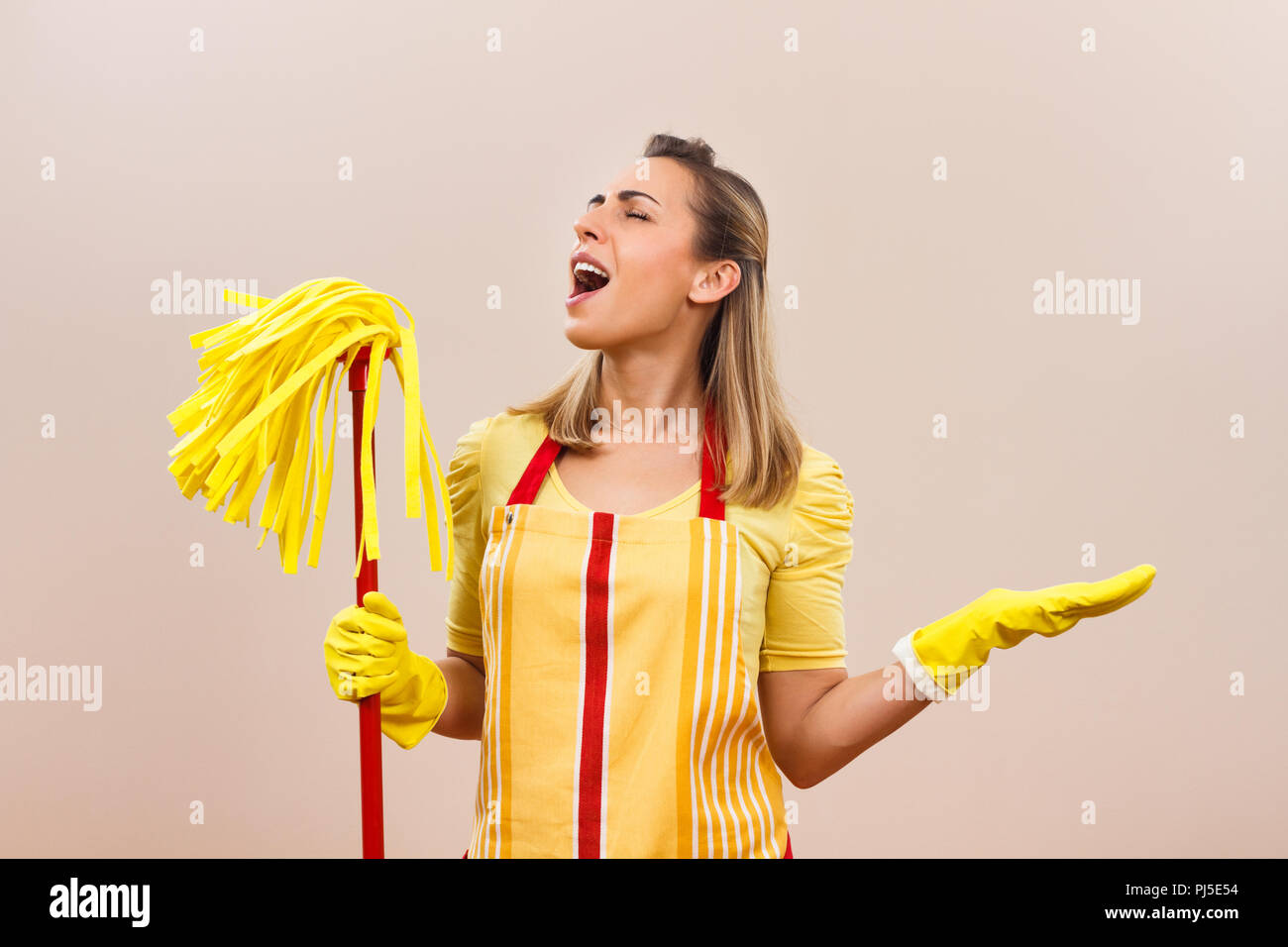 Beautiful housewife is singing while cleaning Stock Photo - Alamy