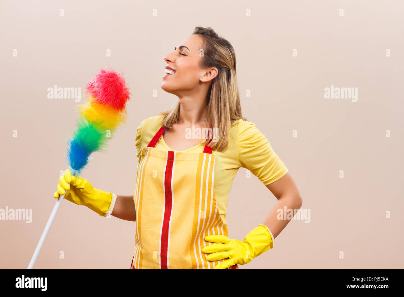 Beautiful housewife is singing while cleaning Stock Photo - Alamy