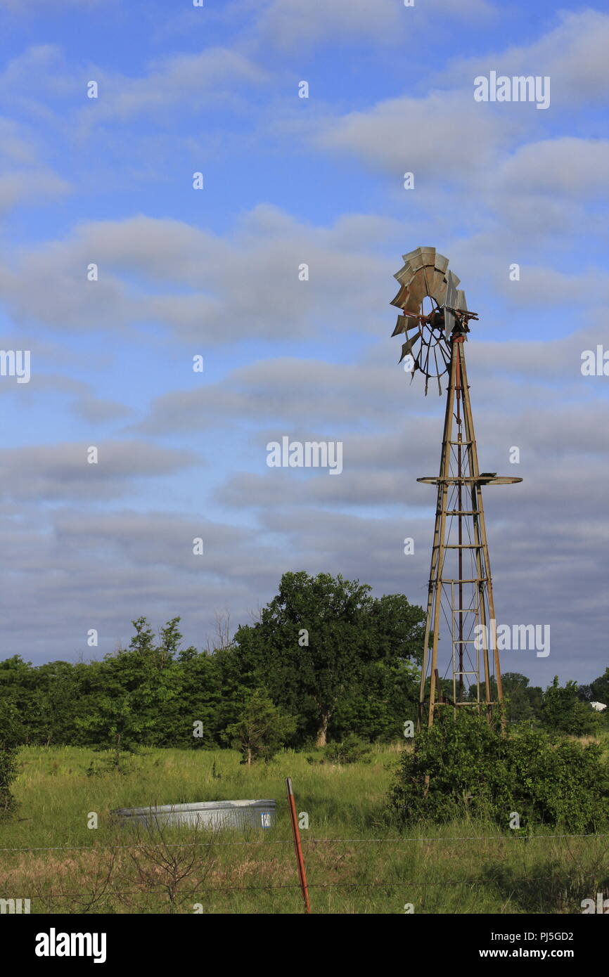 Kansas Windmill in a Pasture with green grass and blue sky with white ...