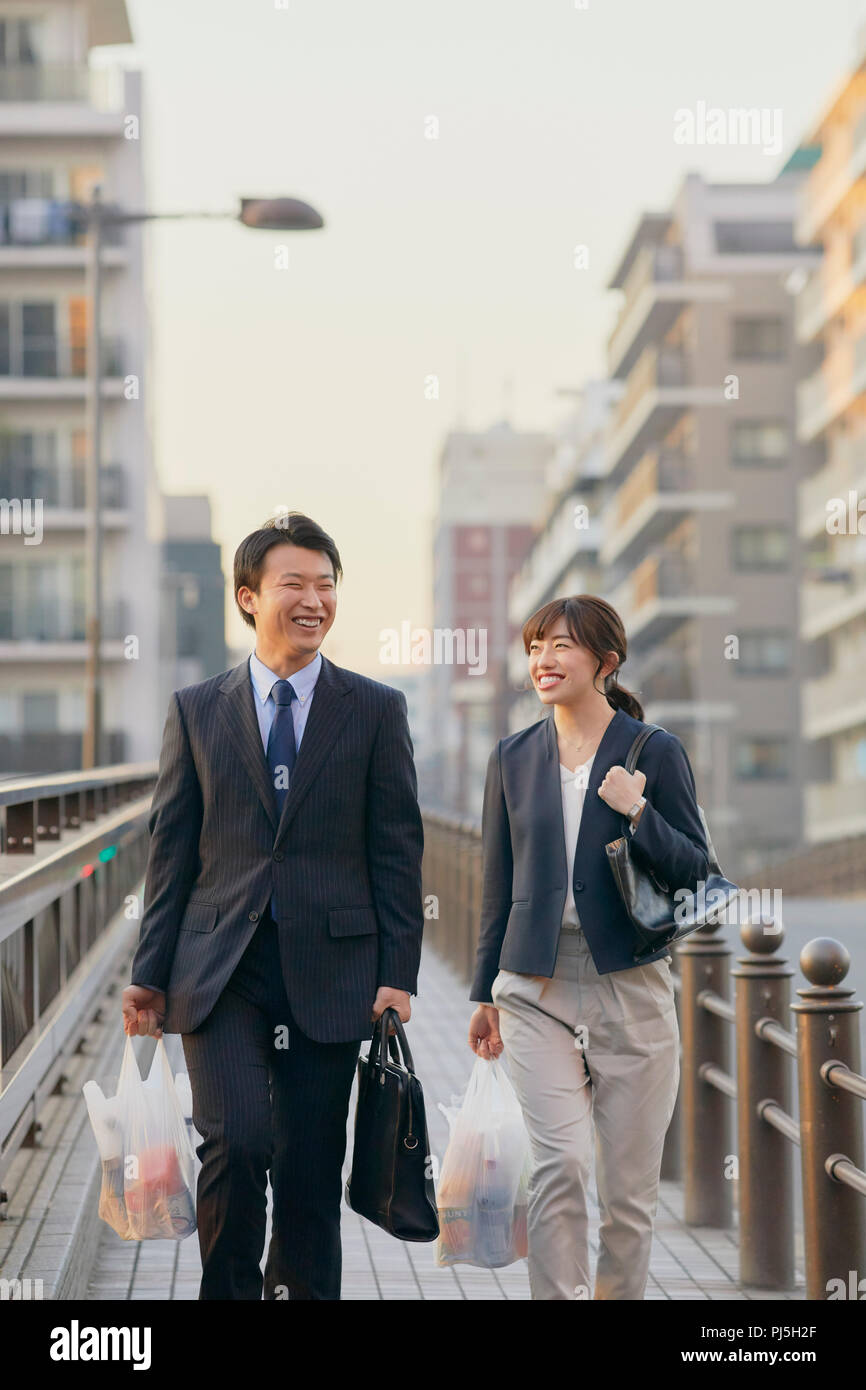 Japanese couple commuting home from work Stock Photo - Alamy
