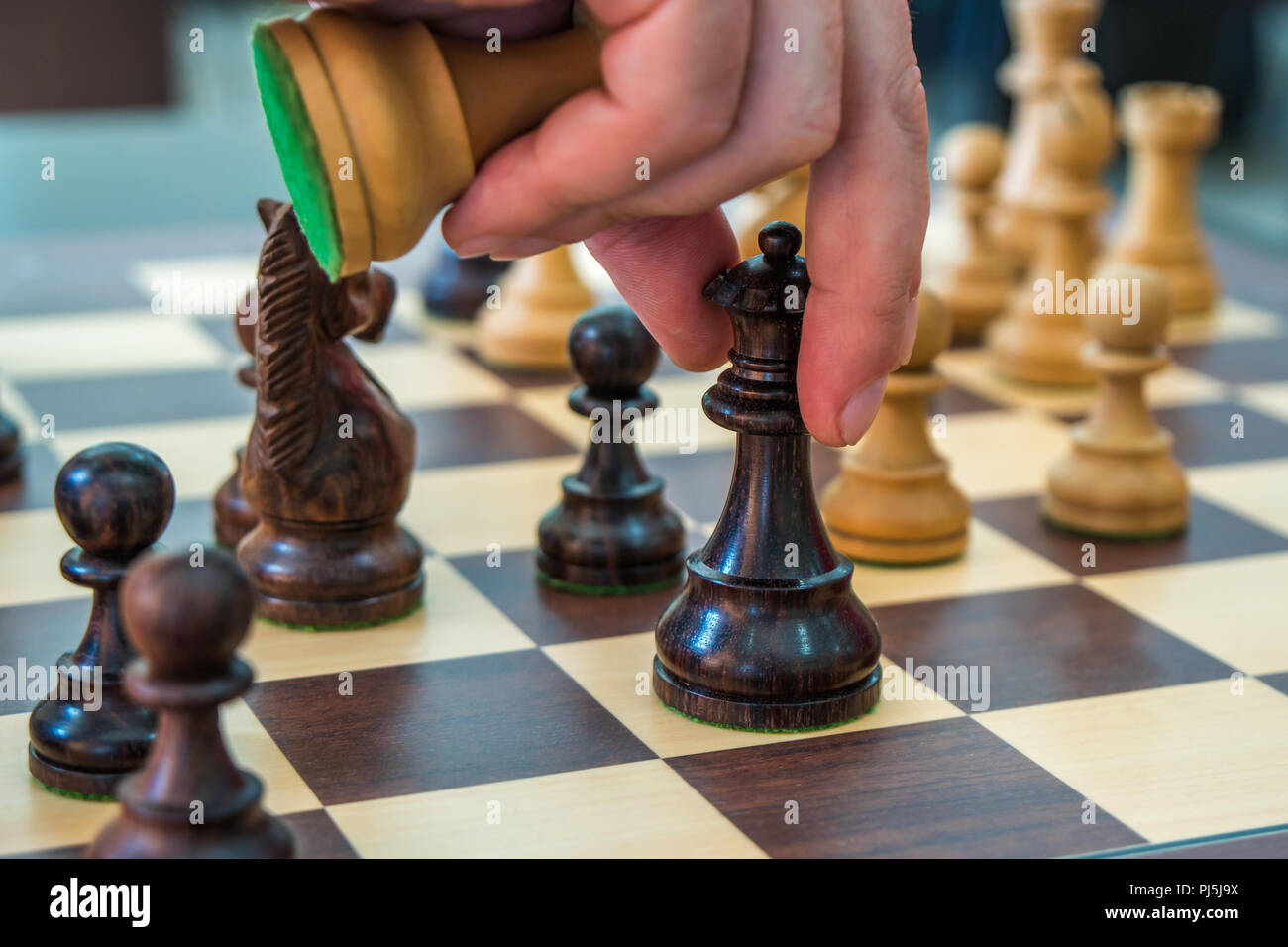 Hand moving a wooden chess figure on a chess board Stock Photo - Alamy