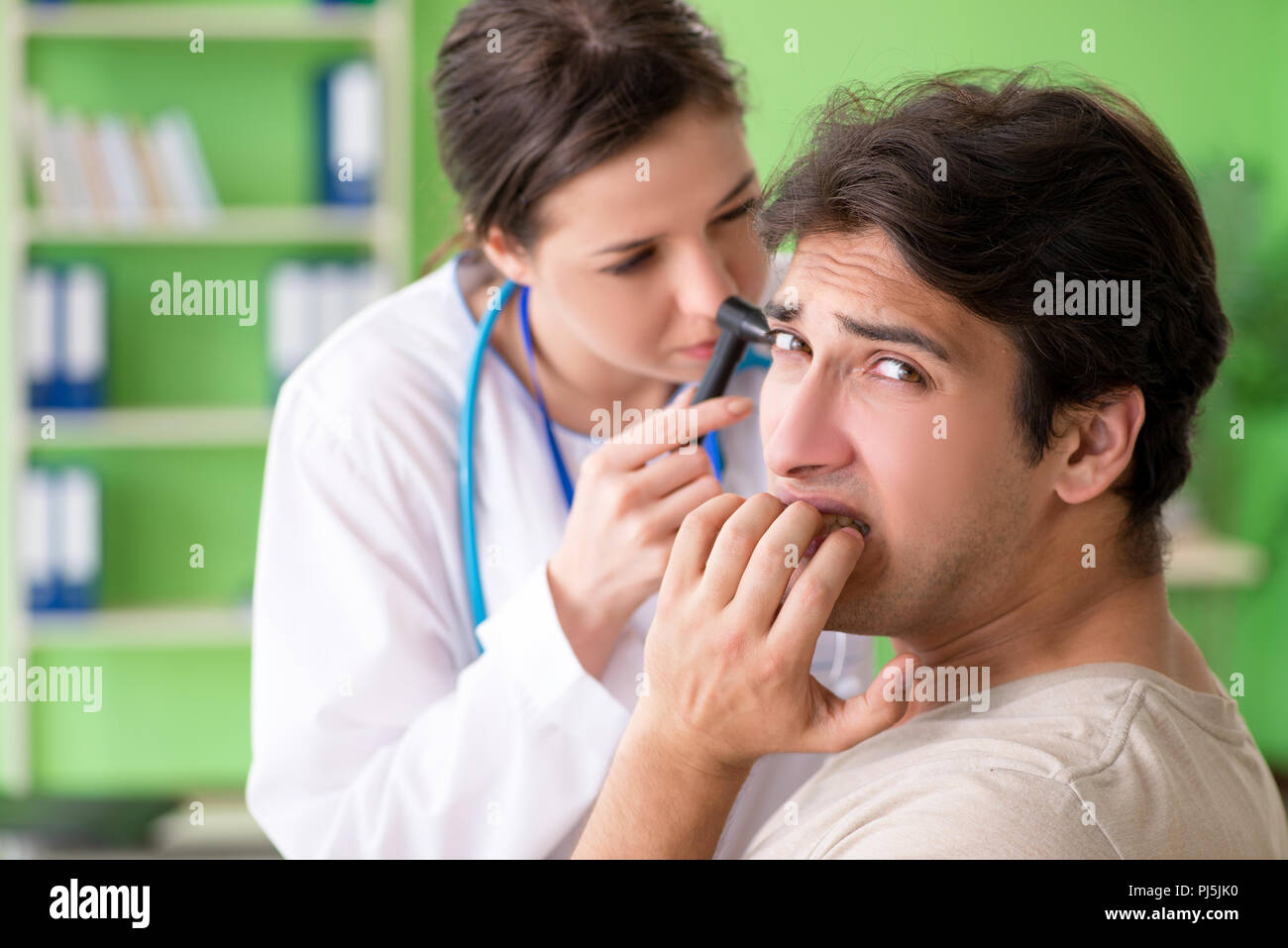 Female doctor checking patient's ear during medical examination Stock ...