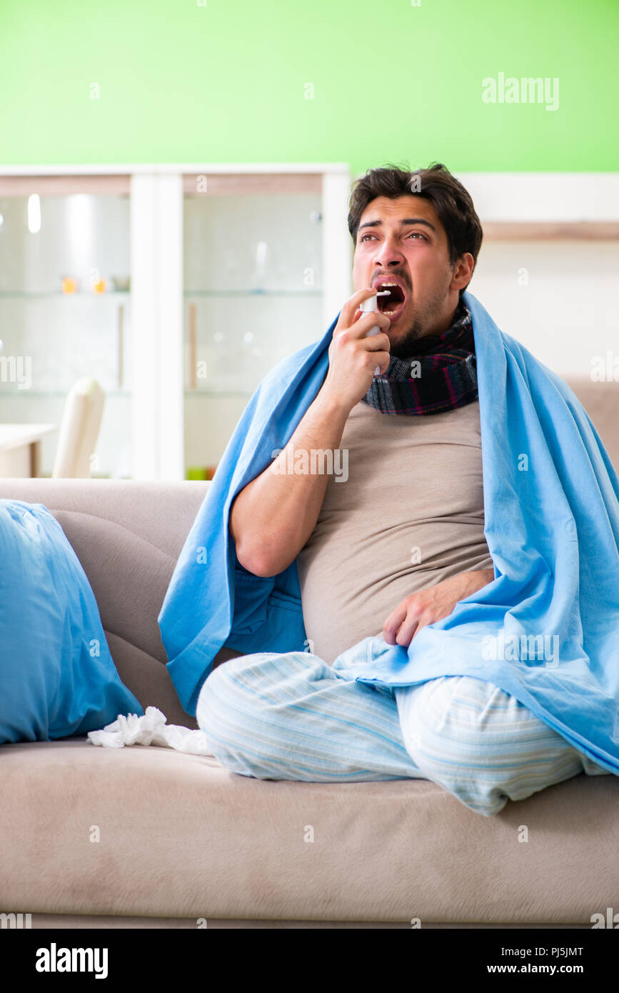 Sick young man suffering from flu at home Stock Photo - Alamy