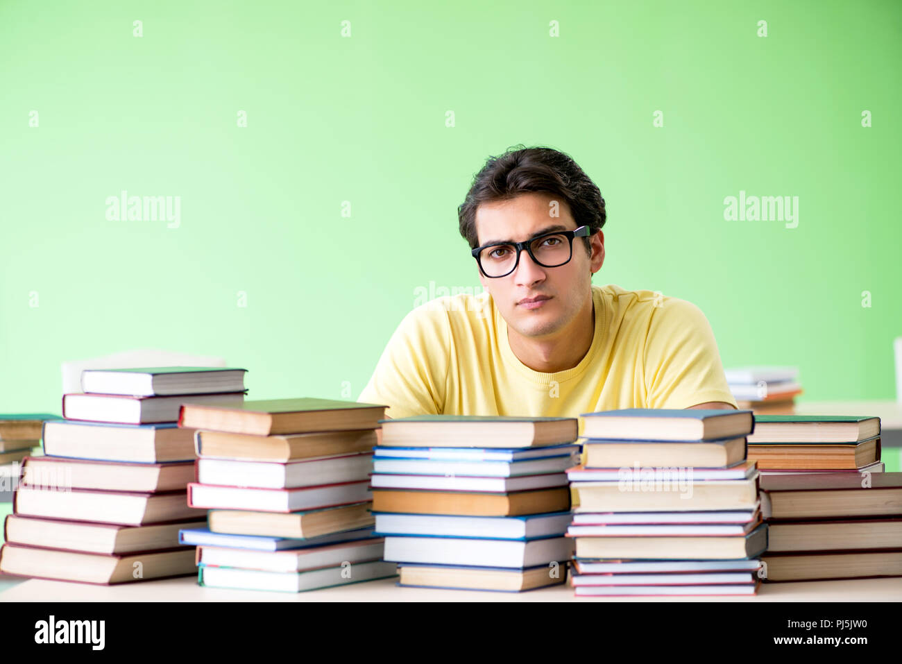 Student with too many books to read before exam Stock Photo - Alamy