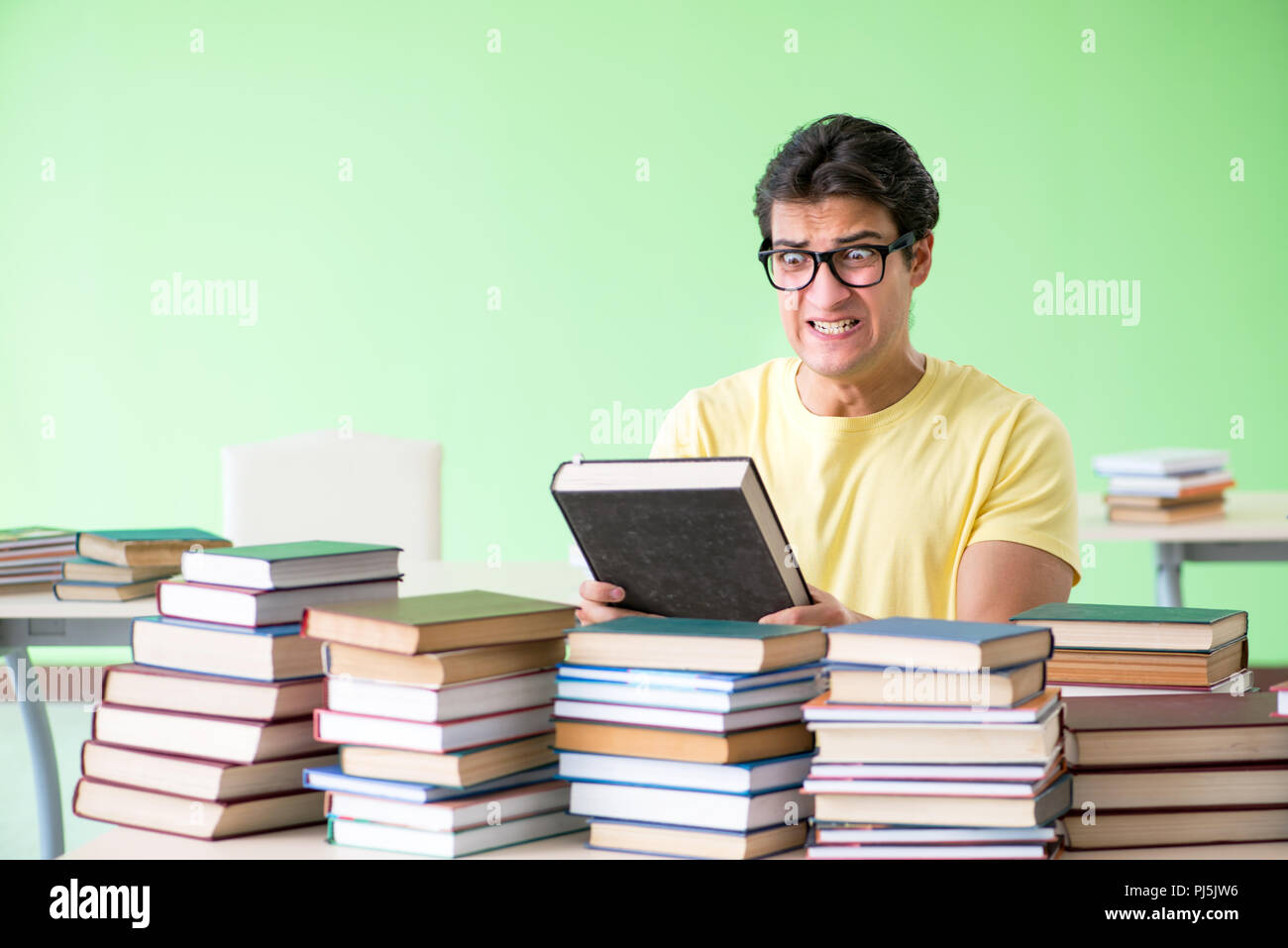 Student with too many books to read before exam Stock Photo - Alamy