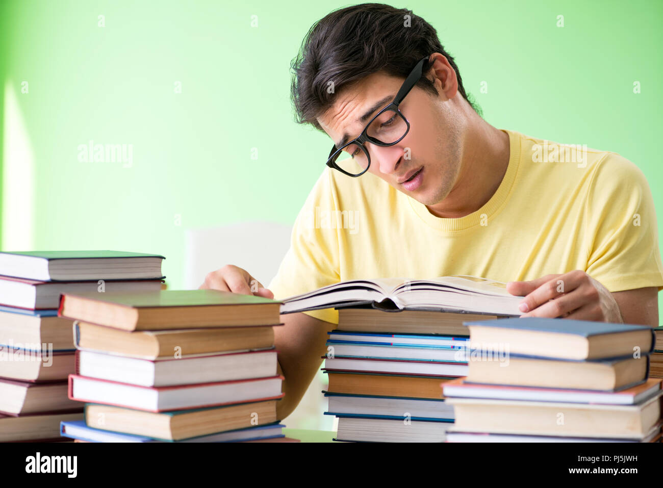 Student with too many books to read before exam Stock Photo - Alamy