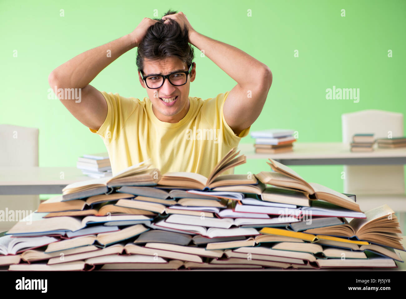 Student with too many books to read before exam Stock Photo - Alamy