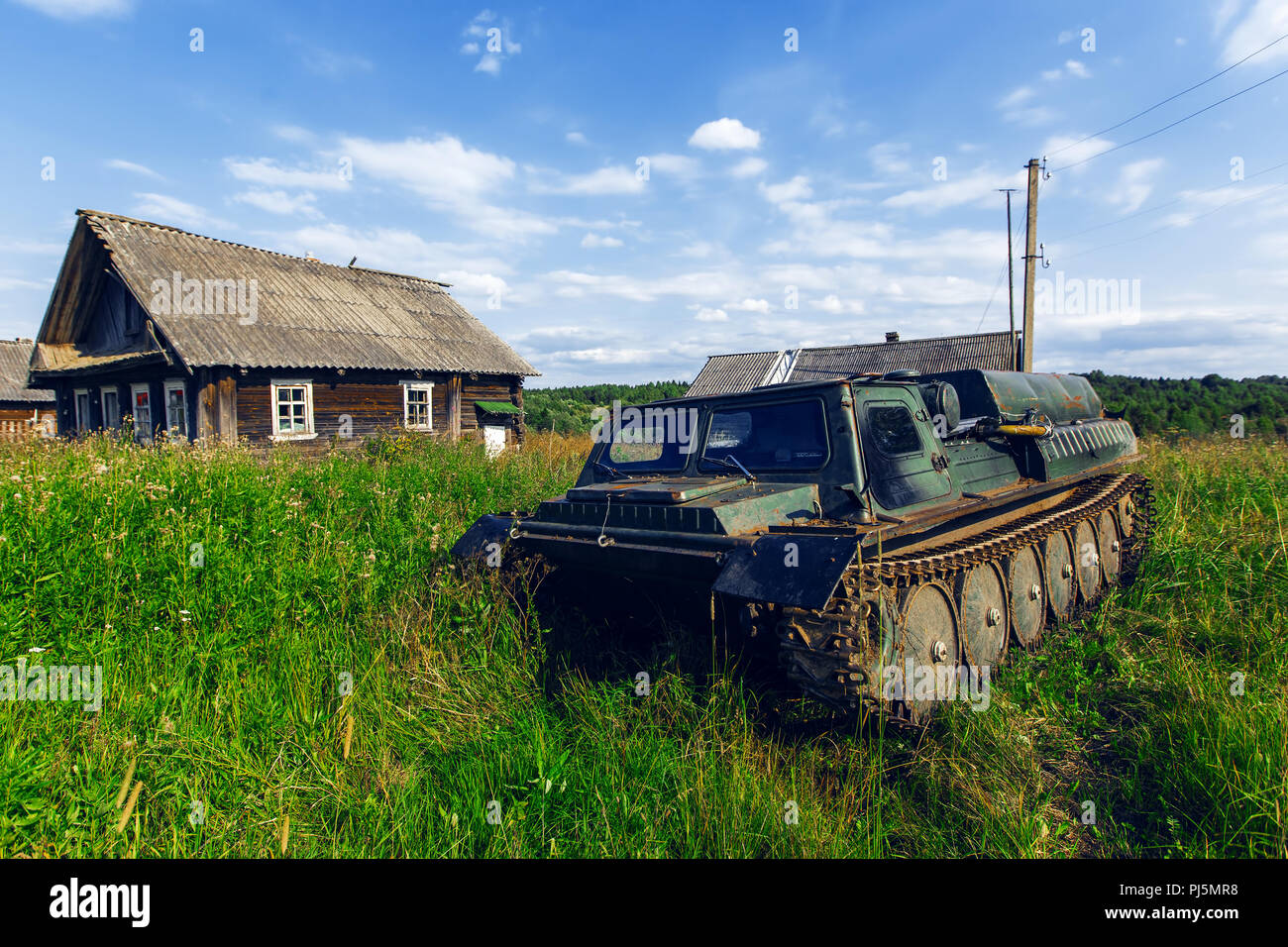 Abandoned all-terrain vehicle. Old village houses Stock Photo - Alamy