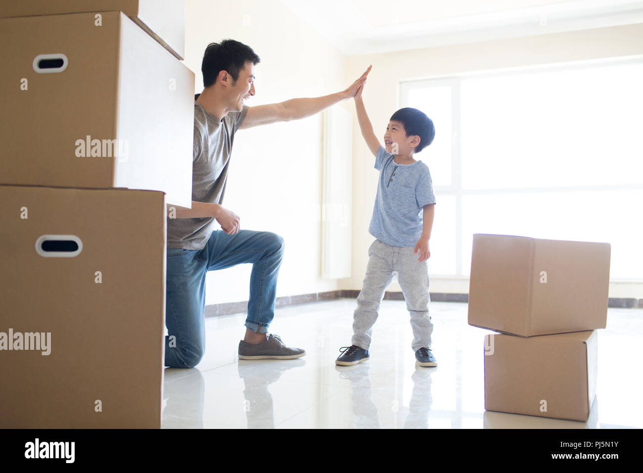 Happy young father and son moving home Stock Photo - Alamy