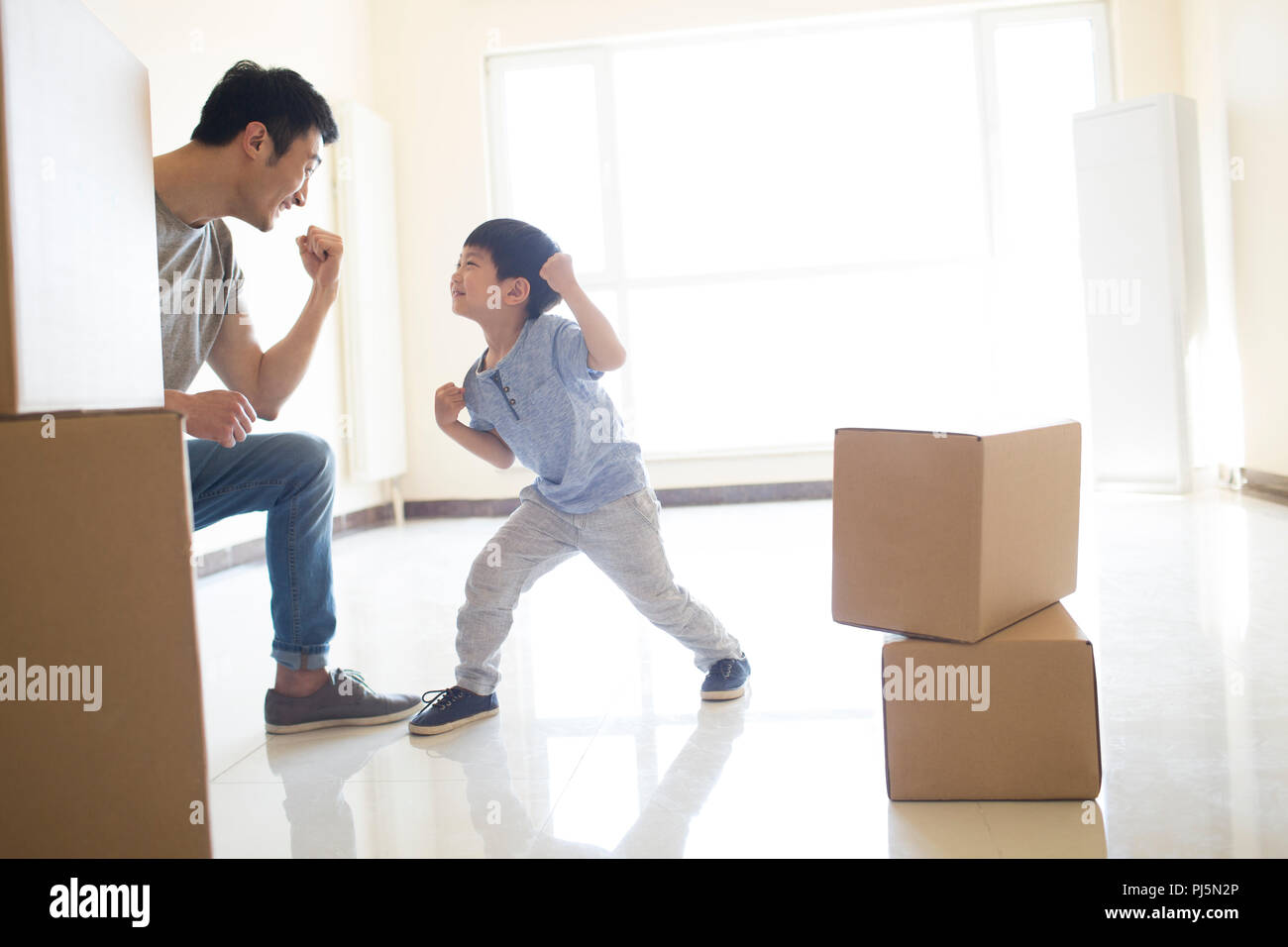 Happy young father and son moving home Stock Photo - Alamy