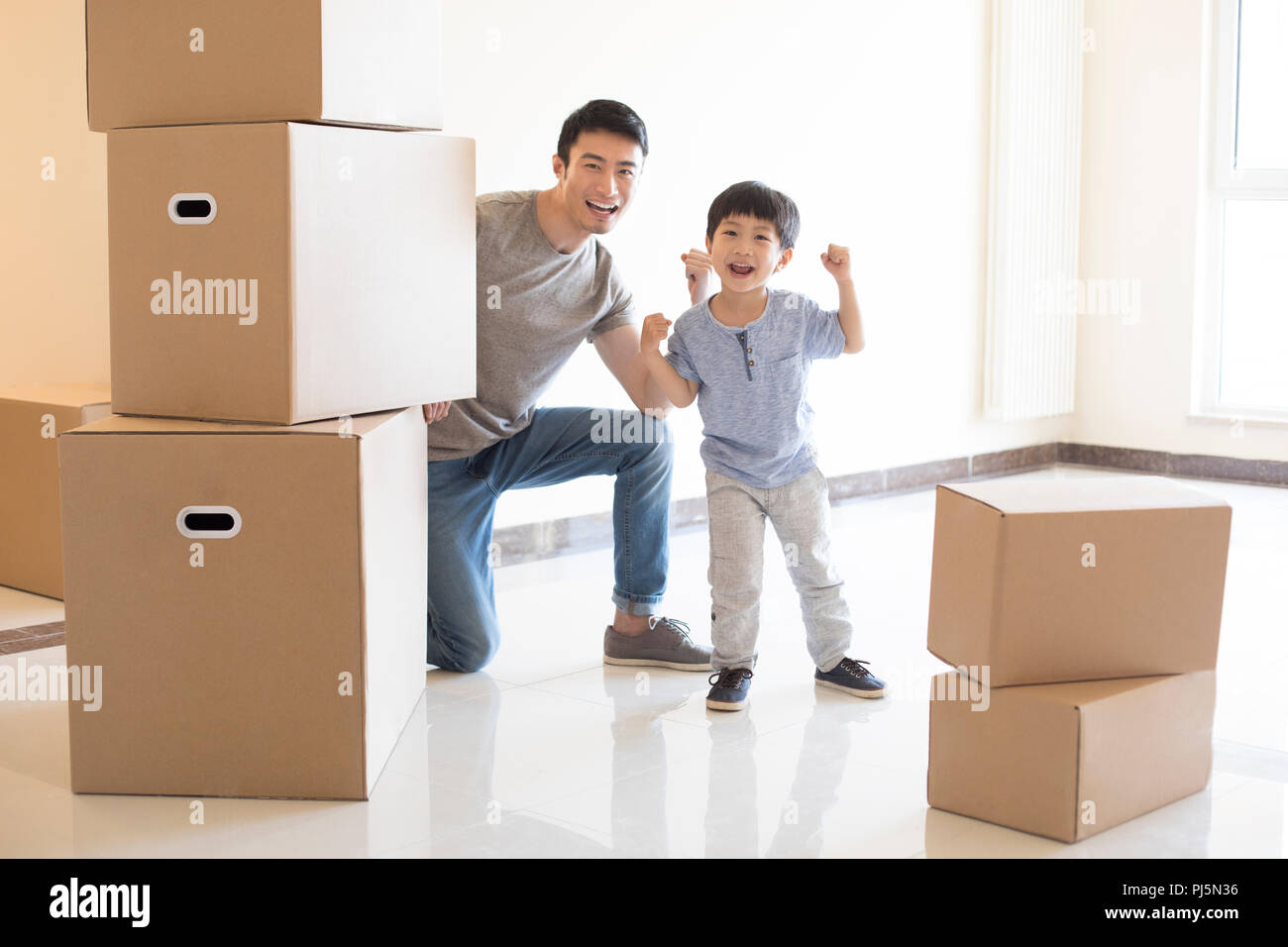 Happy young father and son moving home Stock Photo - Alamy