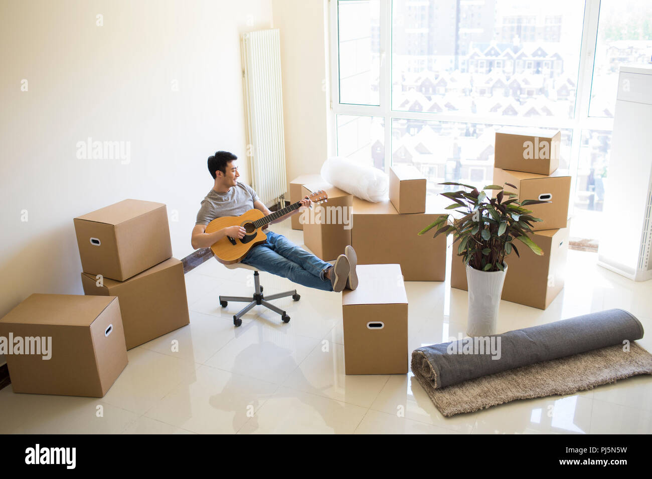 Happy young man moving to a new house Stock Photo - Alamy