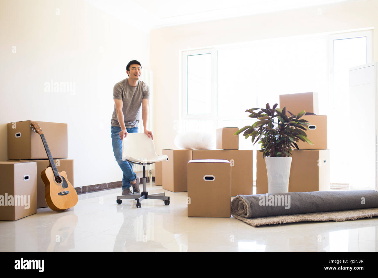 Happy young man moving to a new house Stock Photo - Alamy