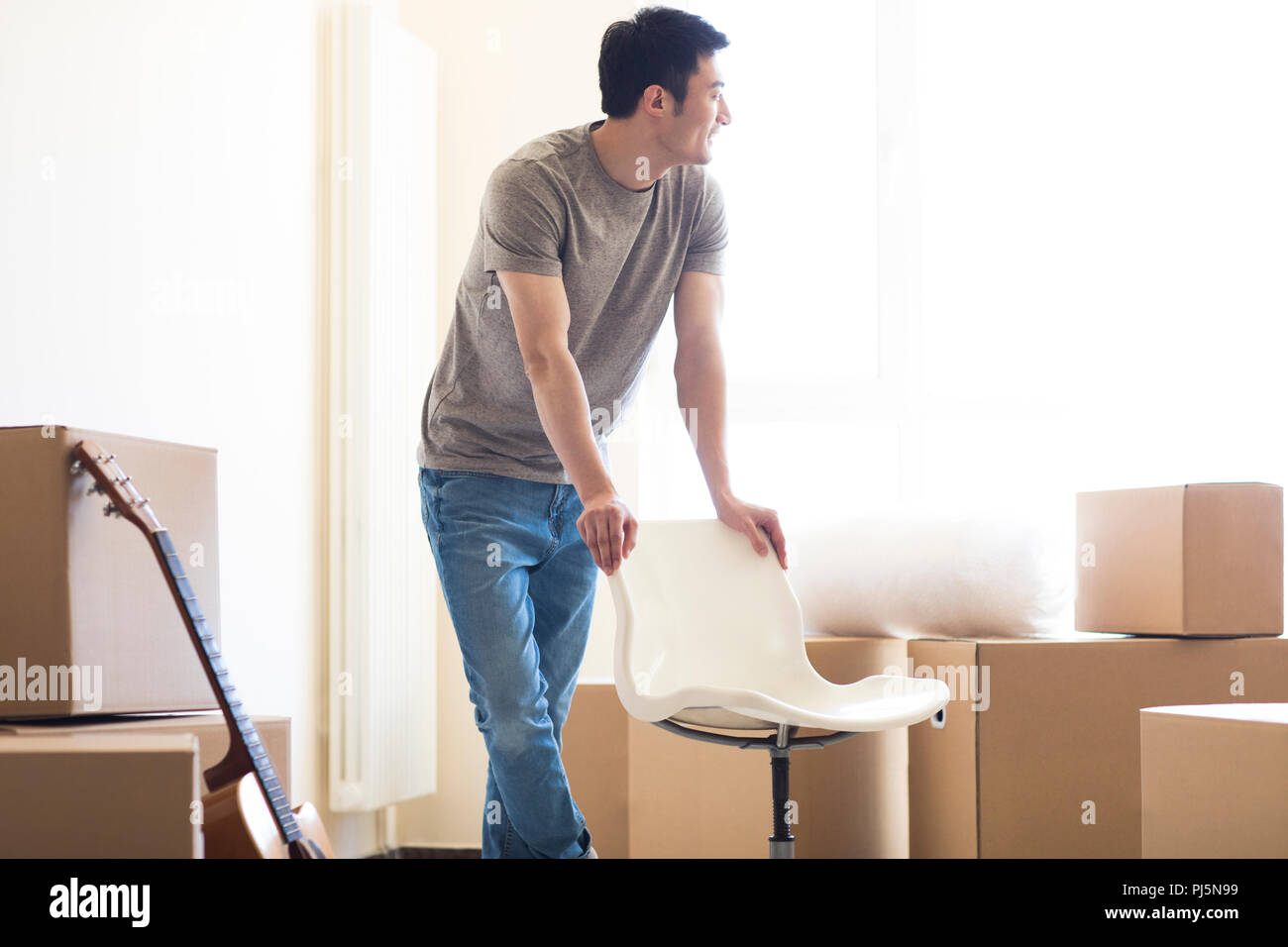 Happy young man moving to a new house Stock Photo - Alamy
