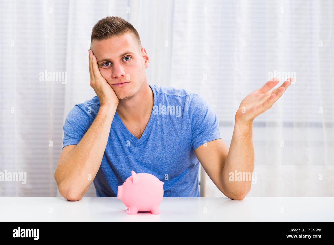 Young man is sad because he is having problem with saving money Stock ...