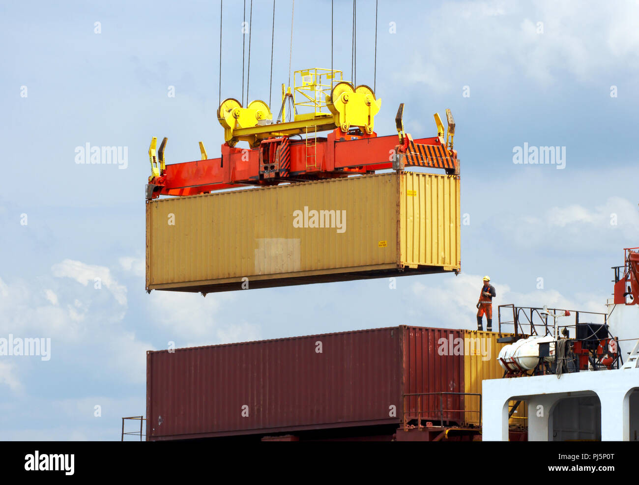 Dockworker checking the precise placement of a container on a ship ...