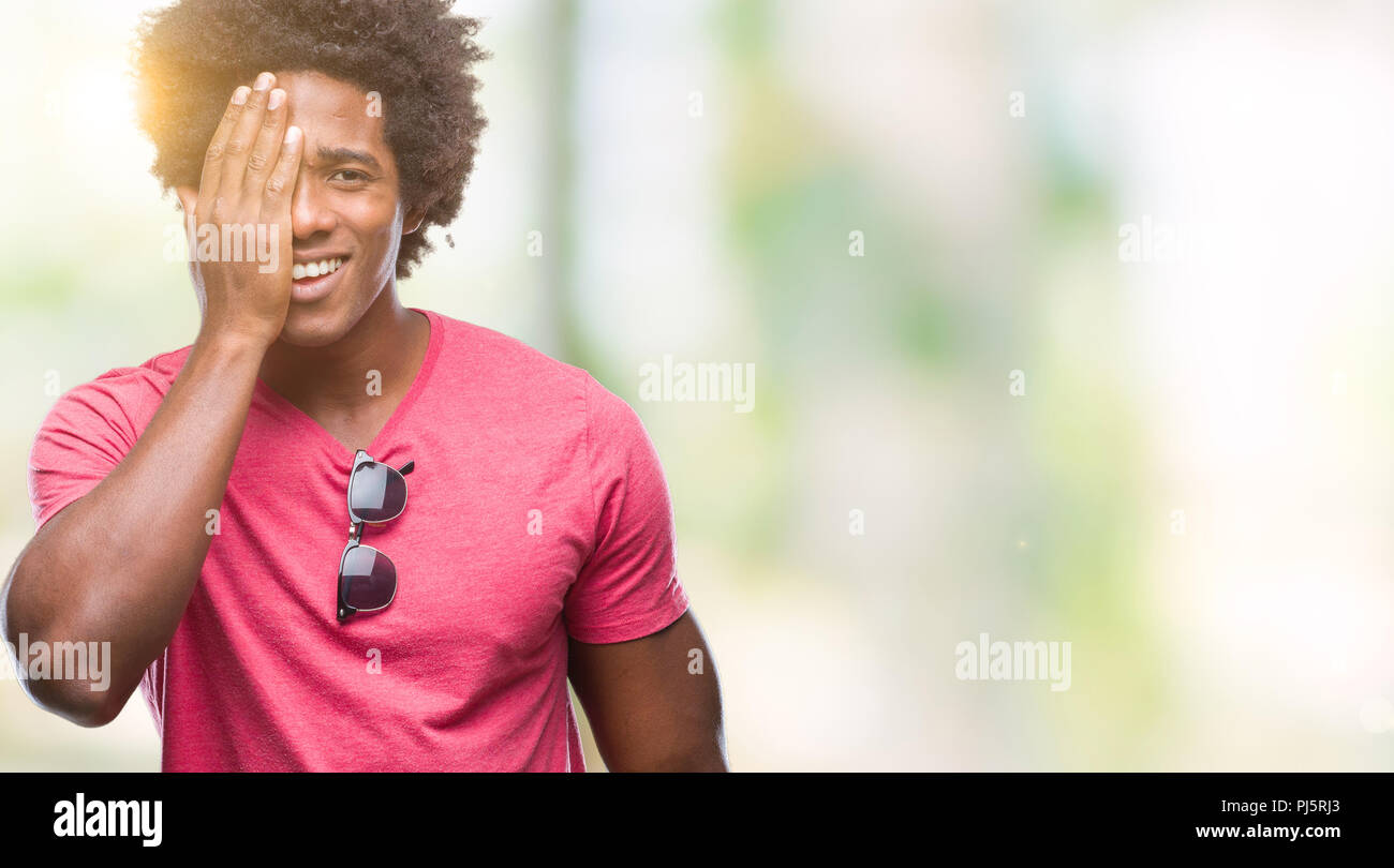 Afro american man over isolated background covering one eye with hand ...