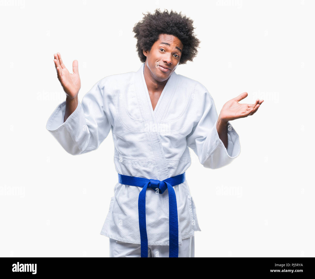 Afro american man wearing karate kimono over isolated background clueless and confused ...