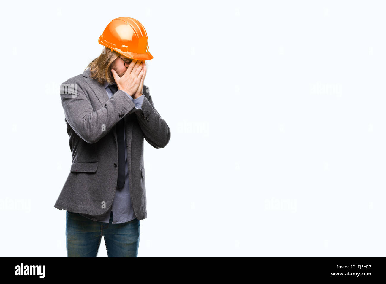 Young handsome architec man with long hair wearing safety helmet over ...