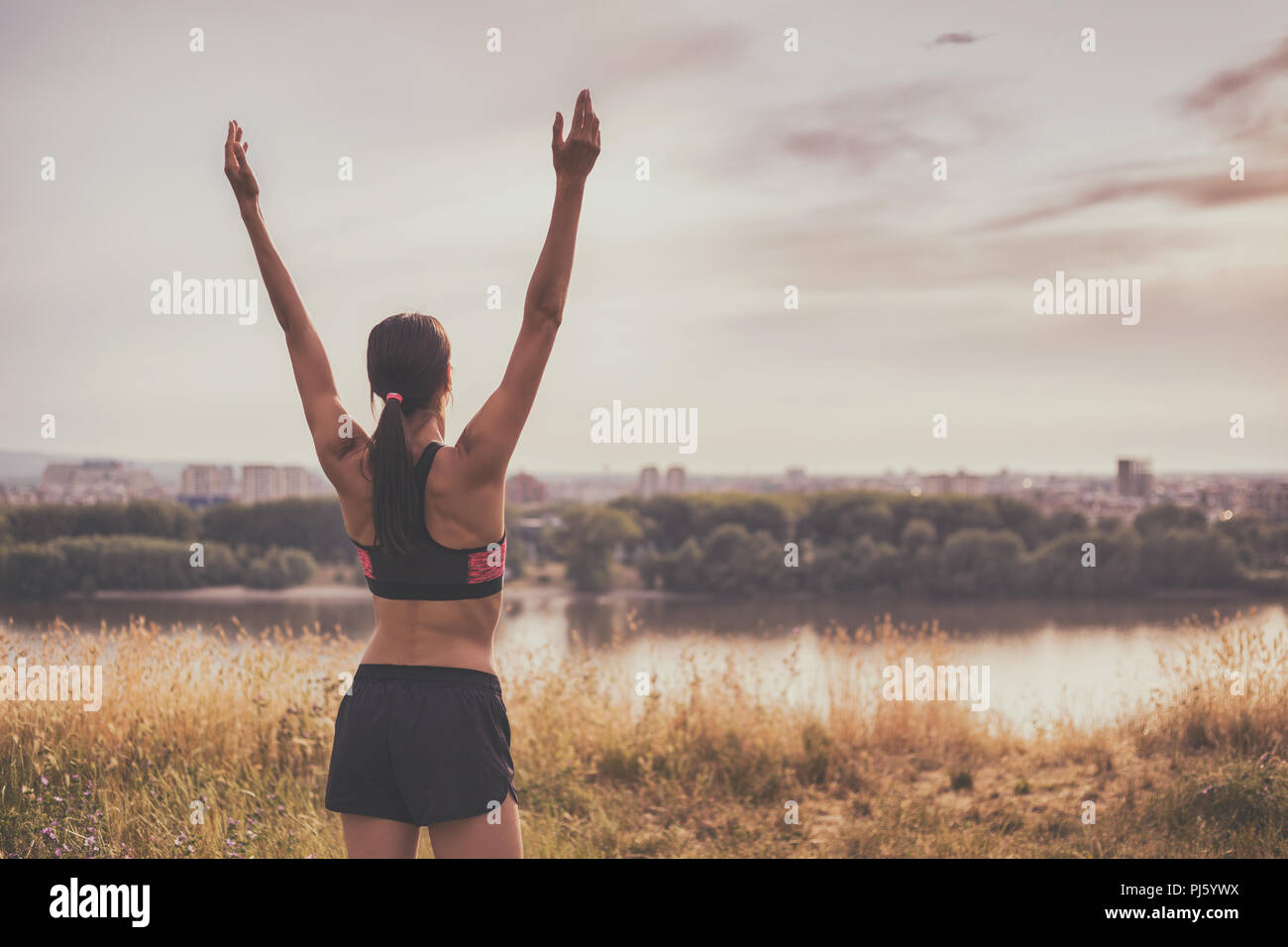 Woman arms raised rear view sky hi-res stock photography and images - Alamy