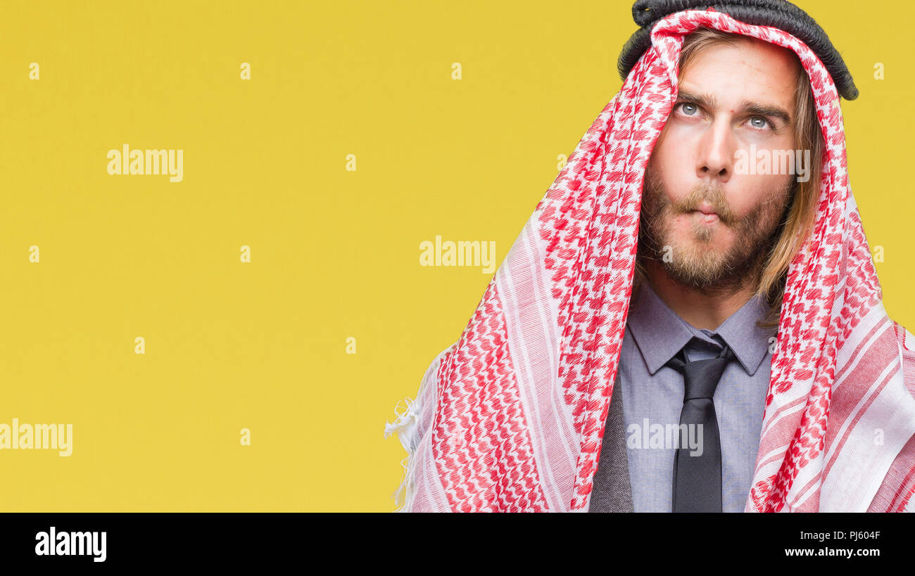 Young handsome arabian man with long hair wearing keffiyeh over ...