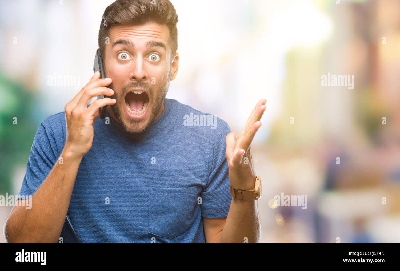 Young handsome man talking on smartphone over isolated background very ...