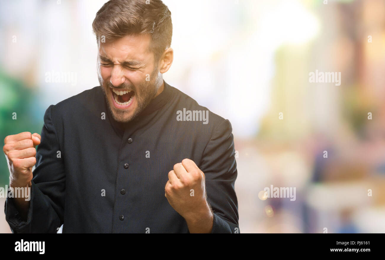 Young catholic christian priest man over isolated background very happy ...