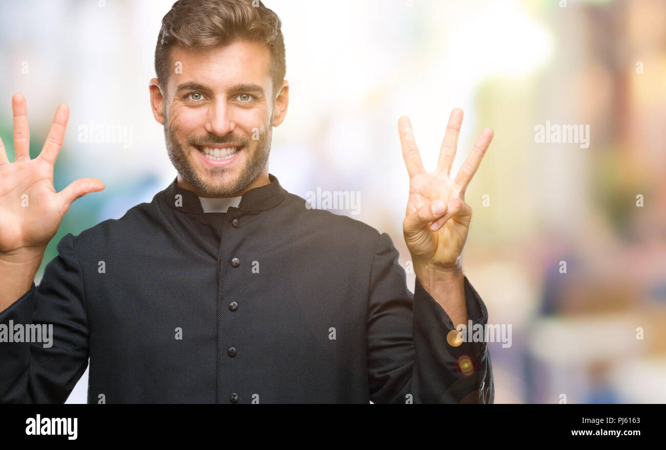 Young catholic christian priest man over isolated background showing ...