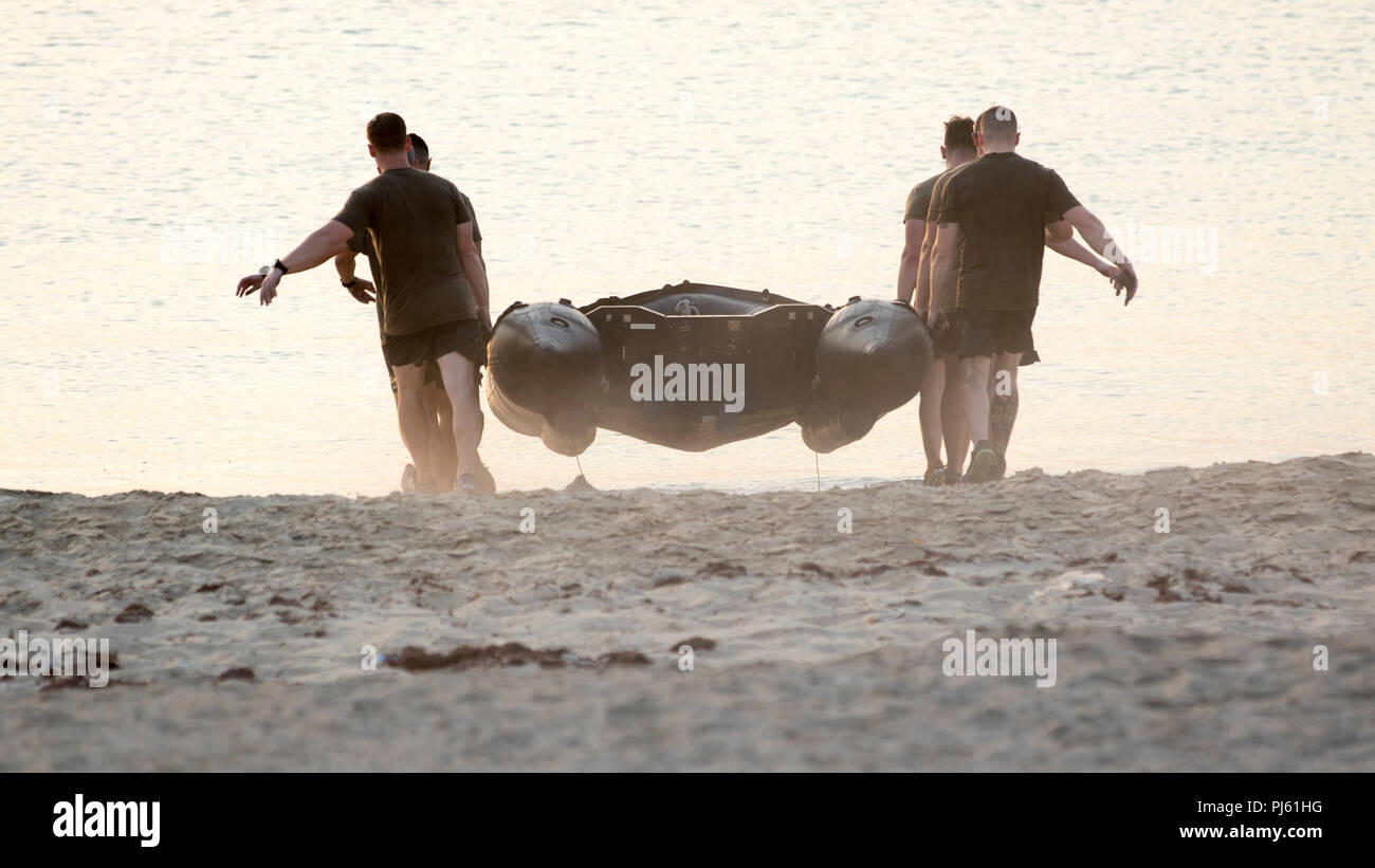 A team of U.S. Army Soldiers carry a Zodiac rigid inflatable boat ...