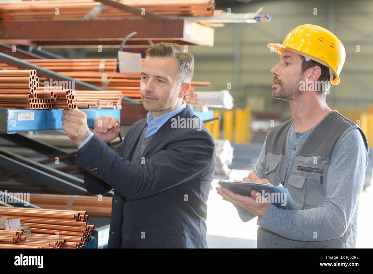 tube factory manager and worker inspecting the warehouse Stock Photo ...