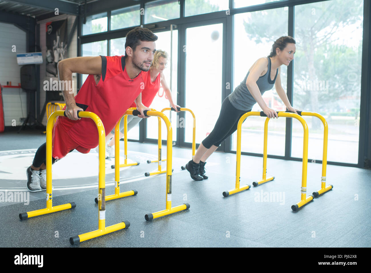 fitness people using a bar in the gym Stock Photo - Alamy
