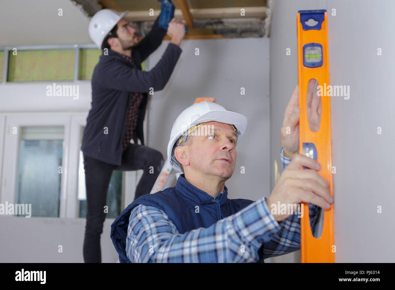 building renovation worker using spirit level Stock Photo - Alamy