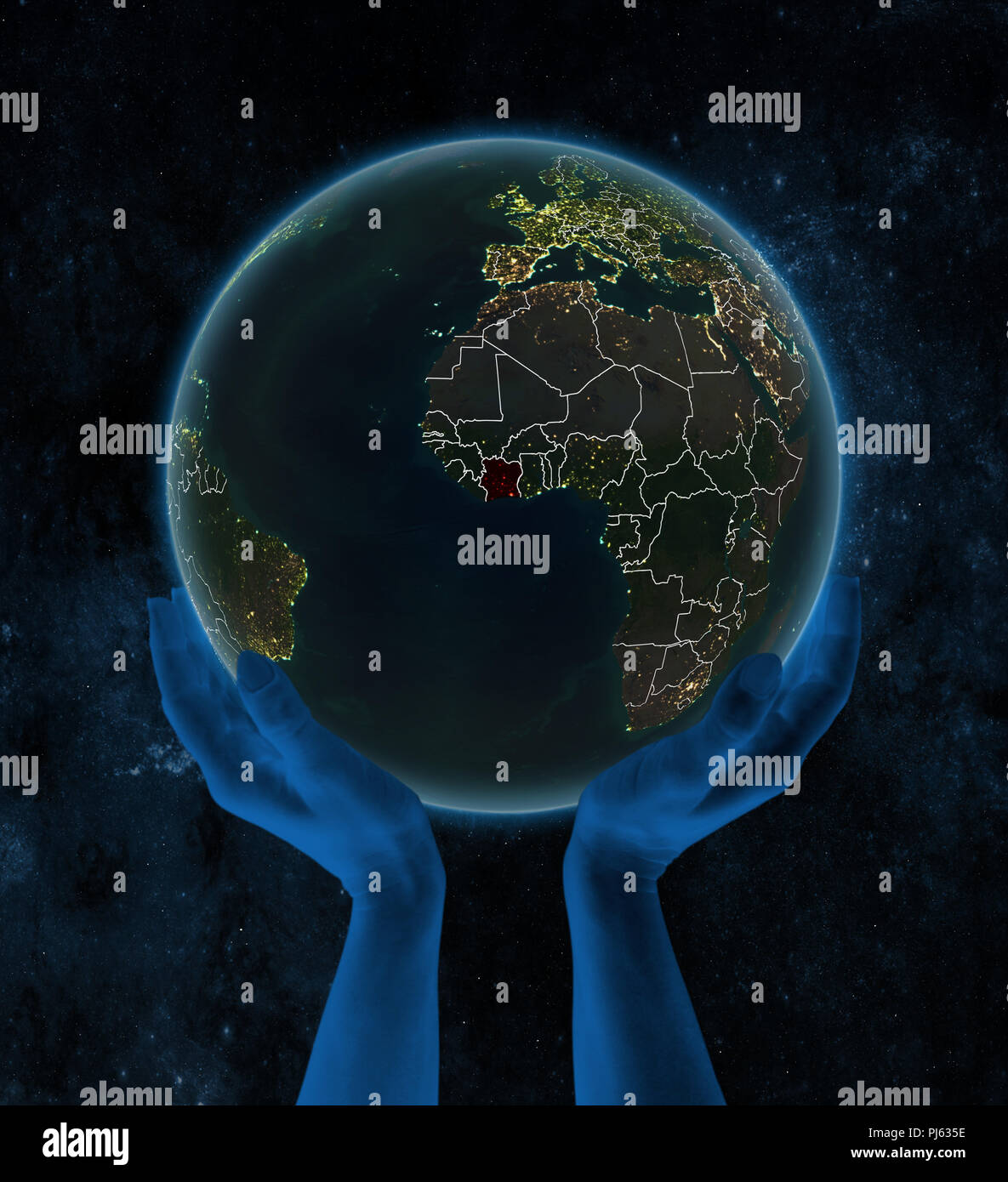 Ivory Coast on night planet Earth with visible country borders in hands ...
