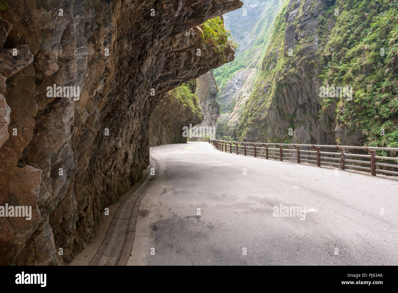 Cliffside road under rock overhang and marble canyons, Tunnel of Nine ...