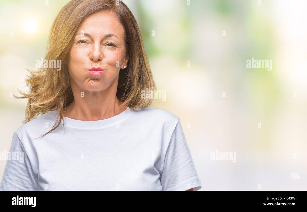 Middle age senior hispanic woman over isolated background puffing ...