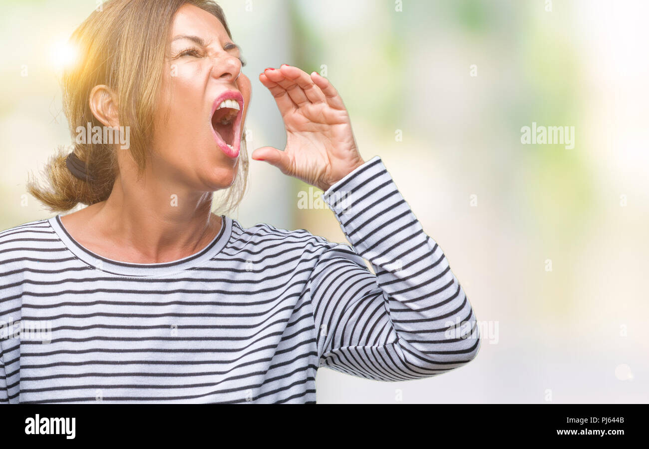 Middle age senior hispanic woman over isolated background shouting and ...