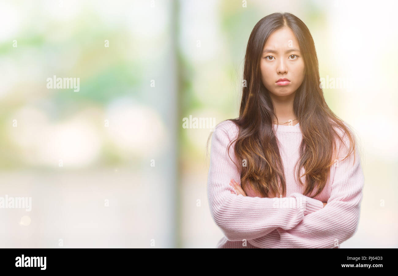 Young asian woman over isolated background skeptic and nervous ...