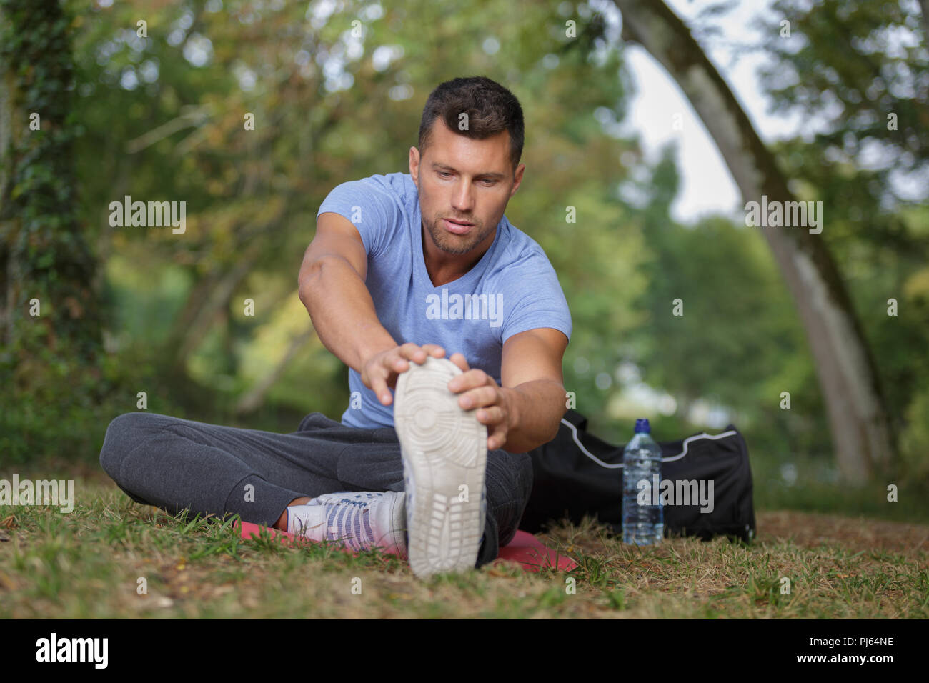 man stretching before running on a forest trail Stock Photo - Alamy