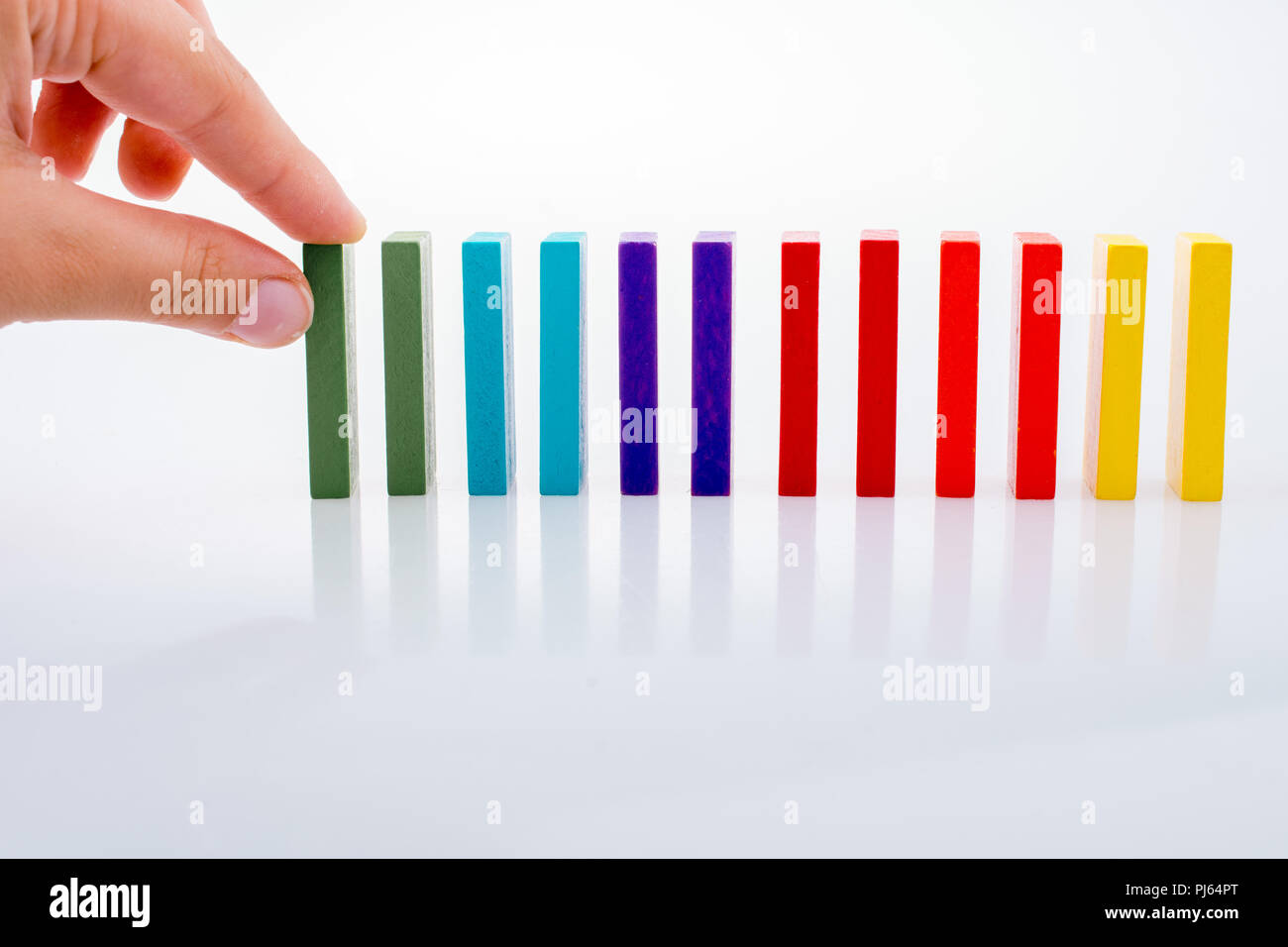 Hand holding color dominoes on a white background Stock Photo - Alamy