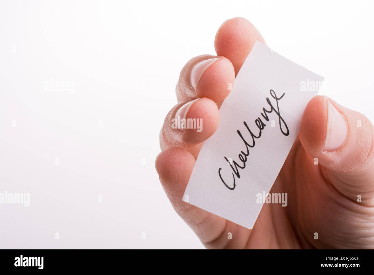 Hand holding a challenge written paper on a white background Stock ...