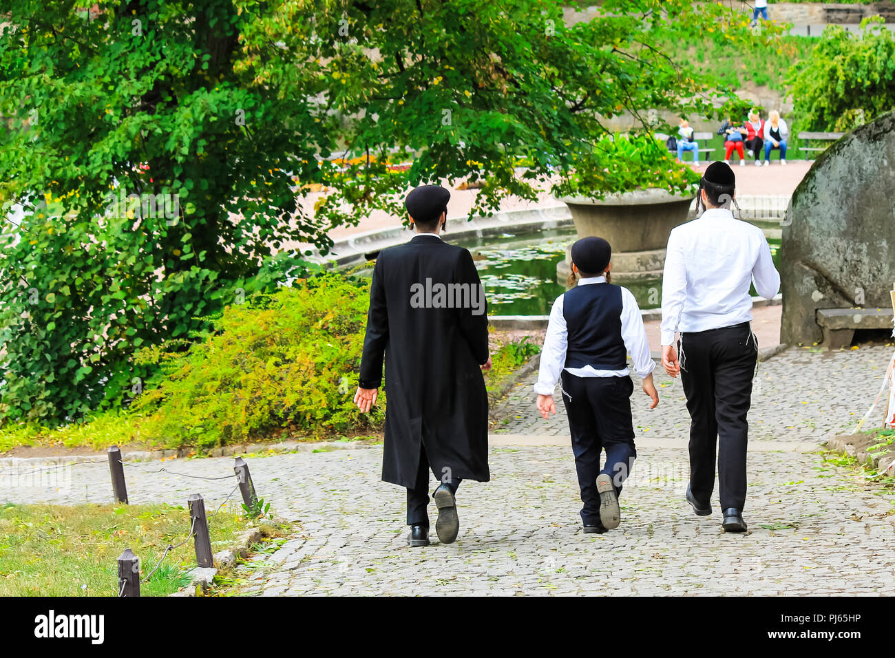 3 boys , a family of Hasidic Jews, in traditional clothes walk in the ...