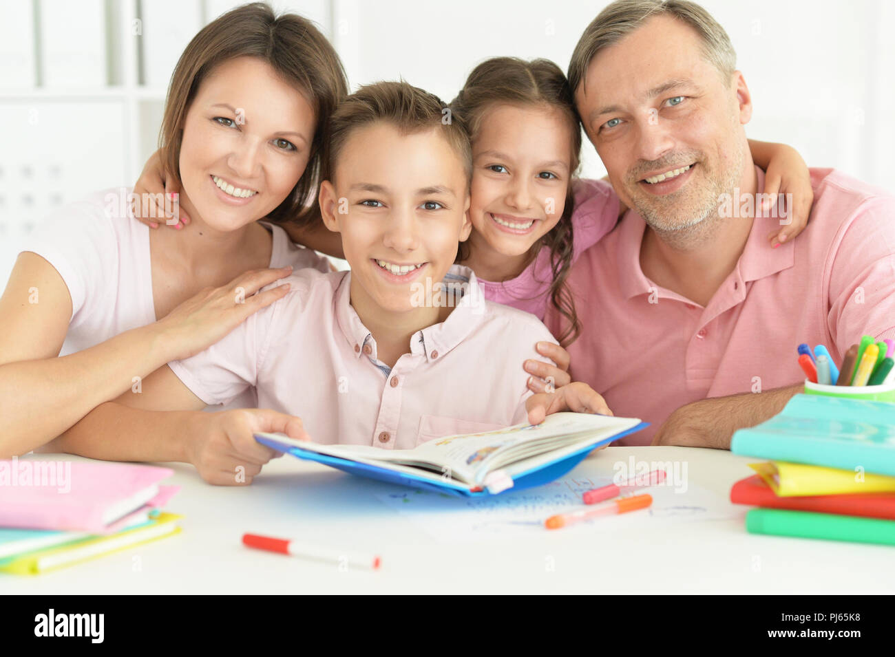 Portrait of big happy family doing homework Stock Photo - Alamy