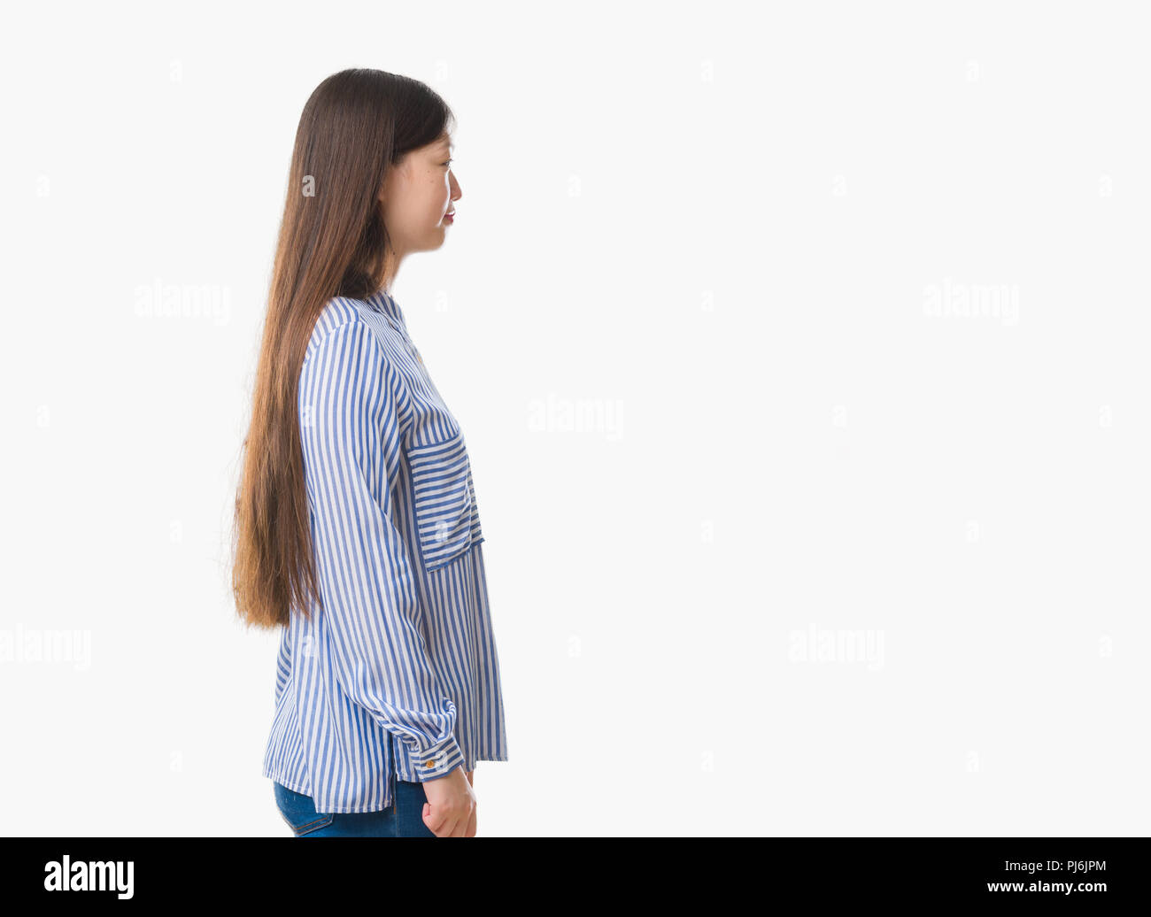 Young Chinese woman over isolated background looking to side, relax ...