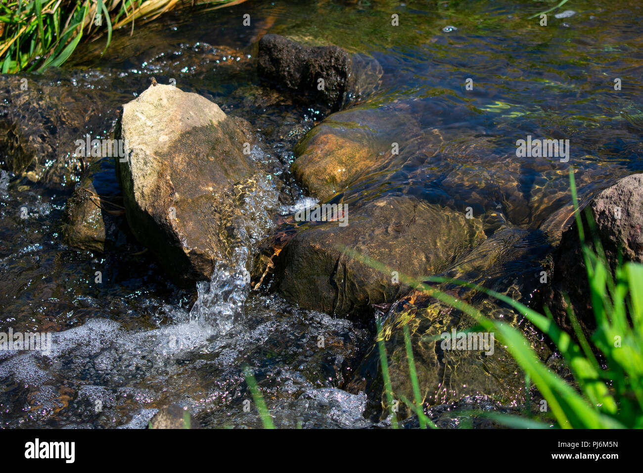 natural stone dam in clear running water Stock Photo - Alamy