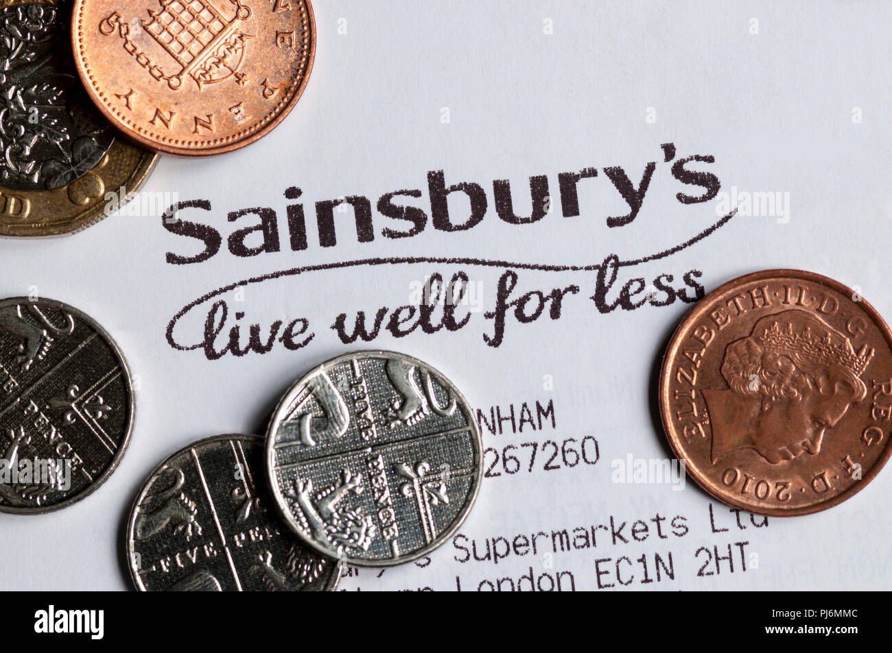 Close-up of Sainsbury's live well for less slogan printed on a till ...