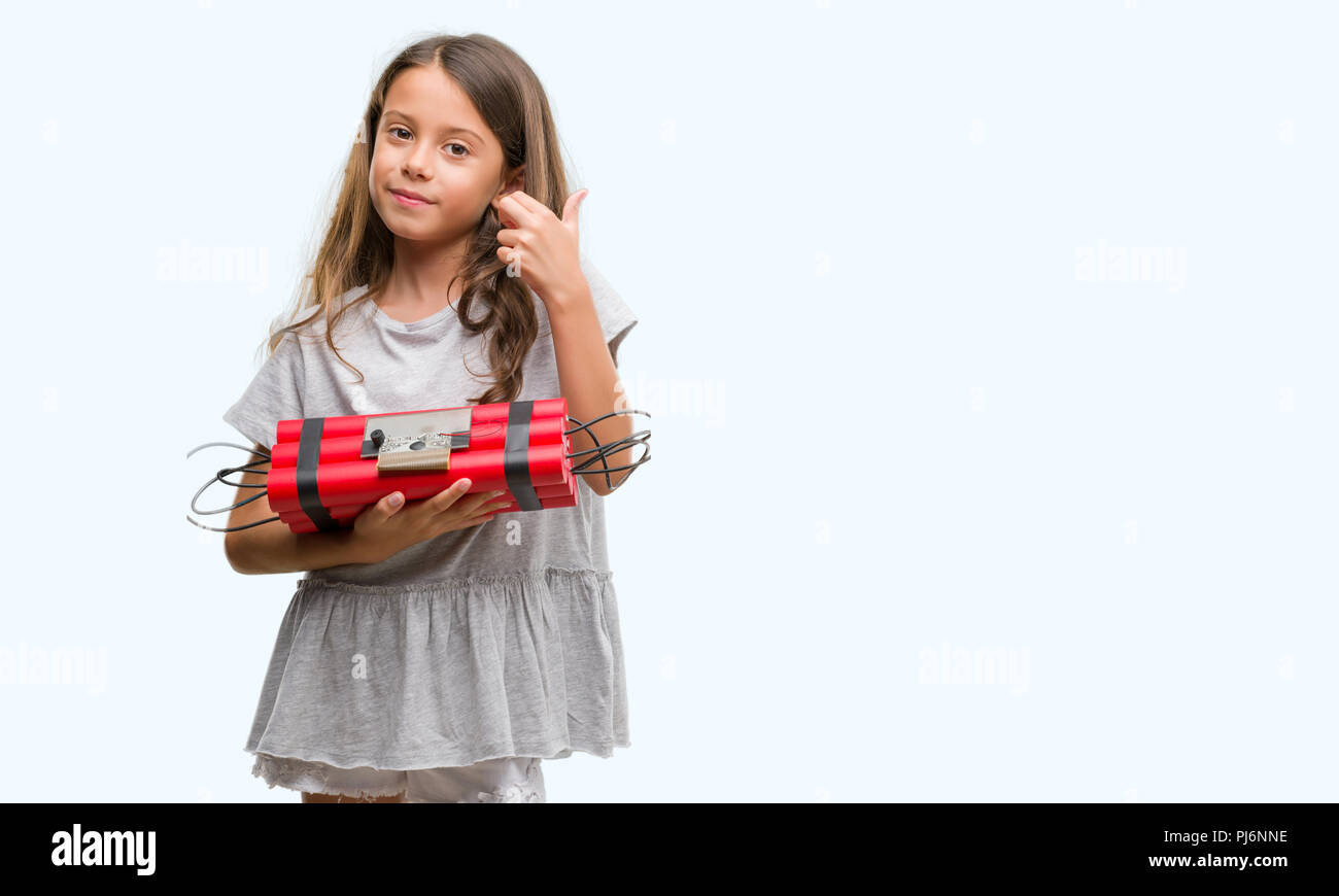 Brunette hispanic girl holding a bomb happy with big smile doing ok ...