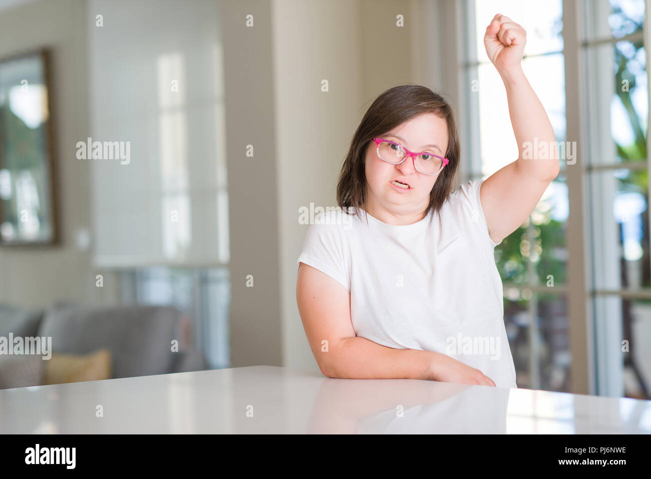 Down syndrome woman at home annoyed and frustrated shouting with anger ...