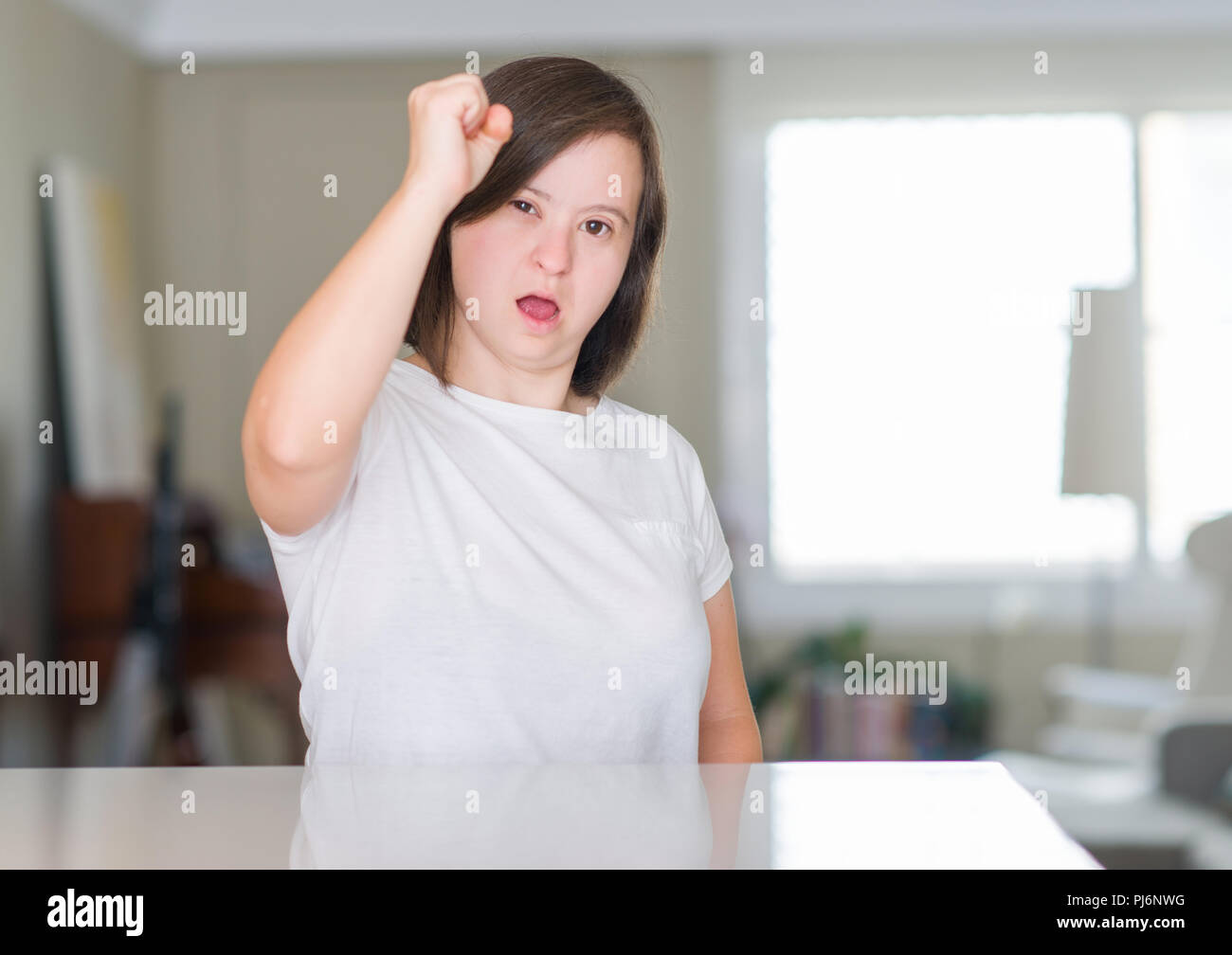 Down syndrome woman at home annoyed and frustrated shouting with anger ...